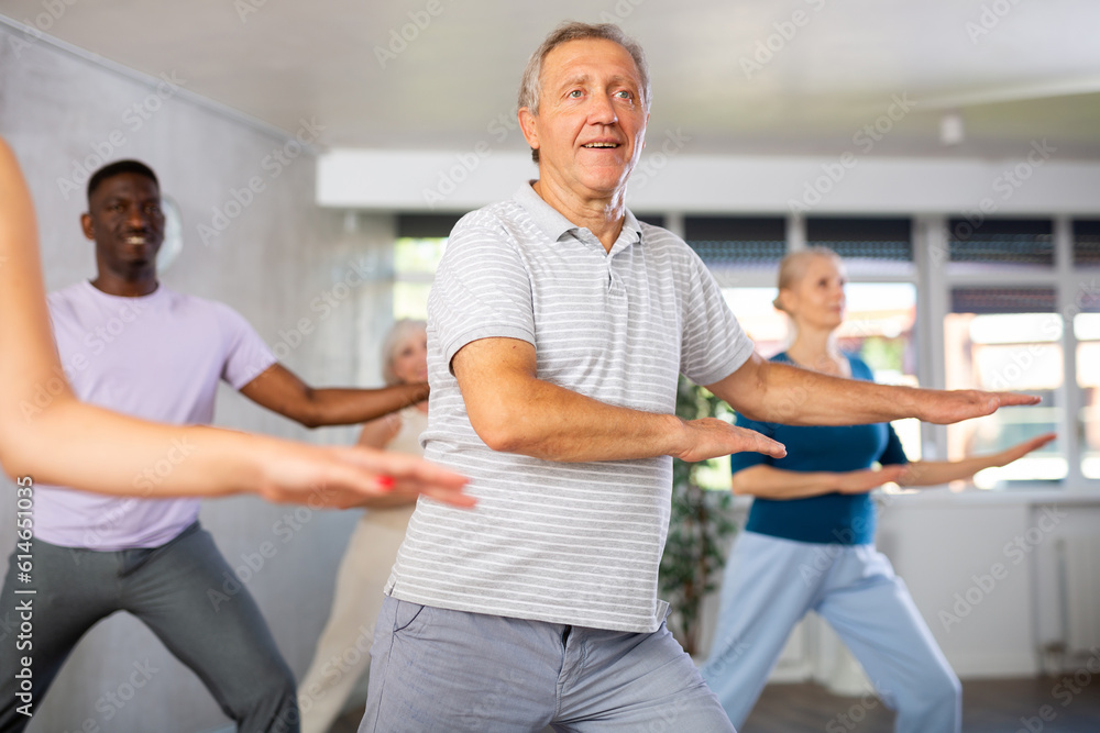 Emotional elderly man practicing hip-hop movements during adult group ...