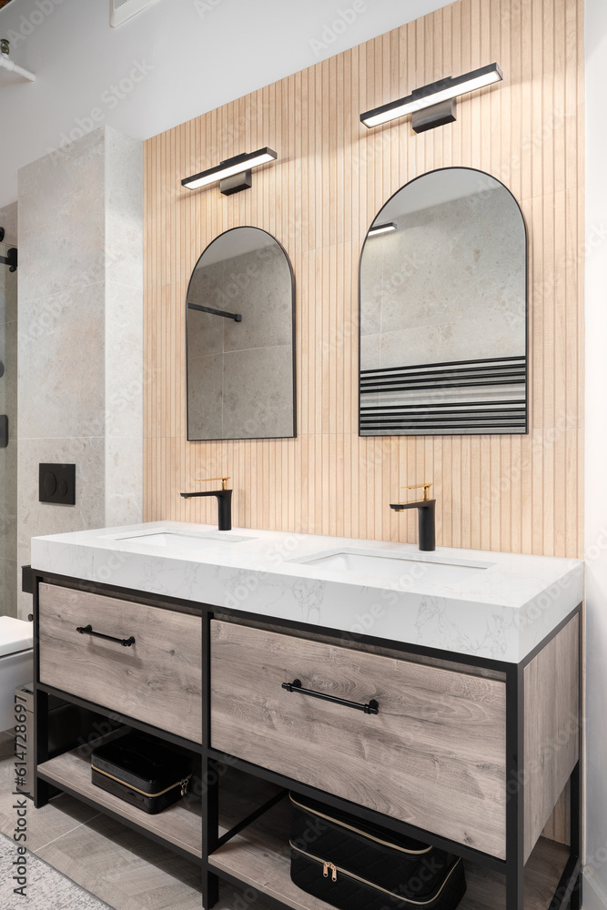 A modern bathroom with white oak wood slat paneling on the wall with ...