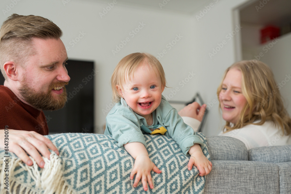 Parents playing with smiling baby Parents with baby with down syndrome ...