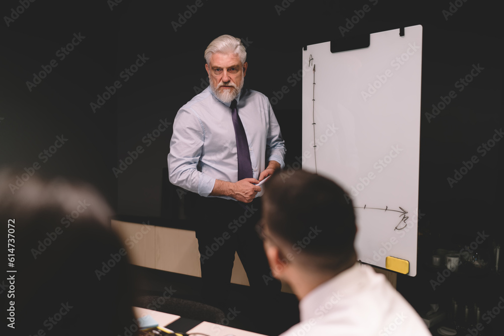 Male boss explaining chart for employees Stock Photo | Adobe Stock