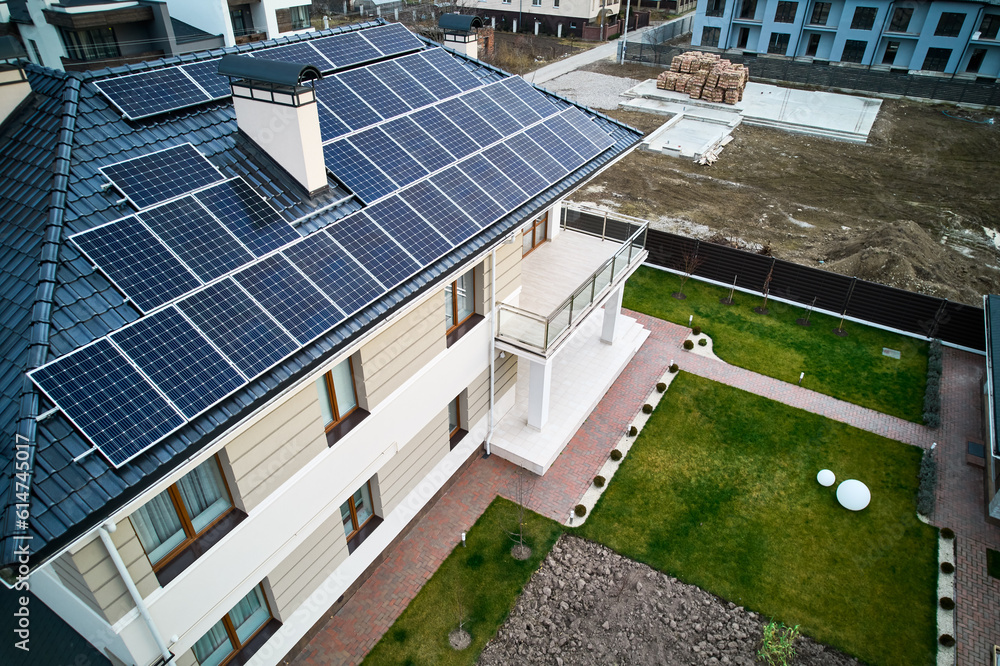 Residential house with photovoltaic solar panel modules on rooftop and ...