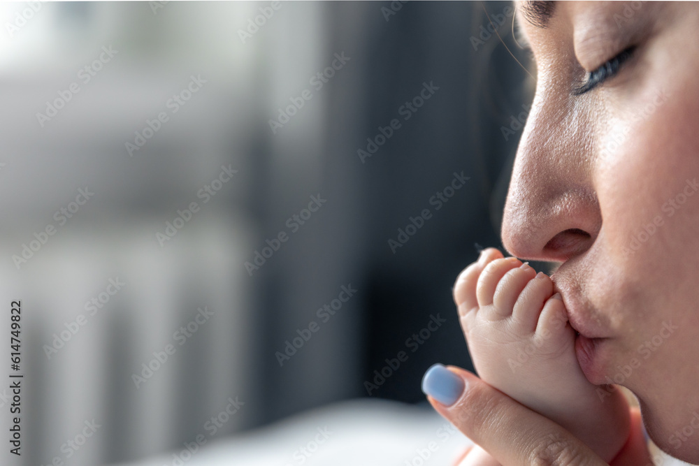 Caring young mother kissing baby's feet, copy space. Stock Photo ...