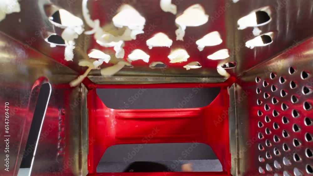 Cheese grated using grater. View from inside. Grating cheese for pizza ...