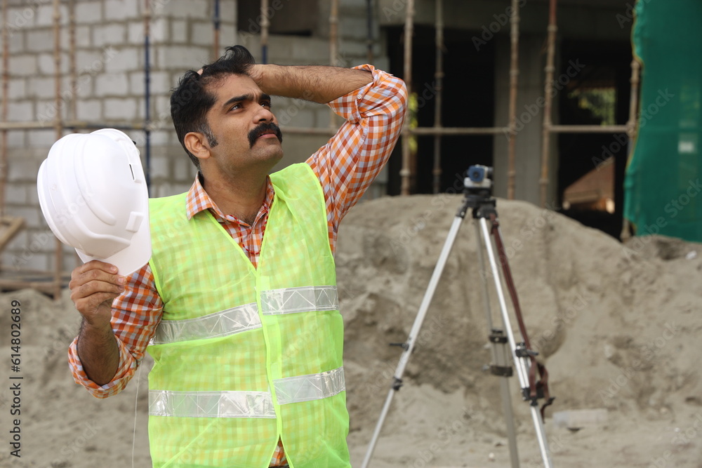 Hardworking Indian Site engineer figuring out the work in progress. On ...