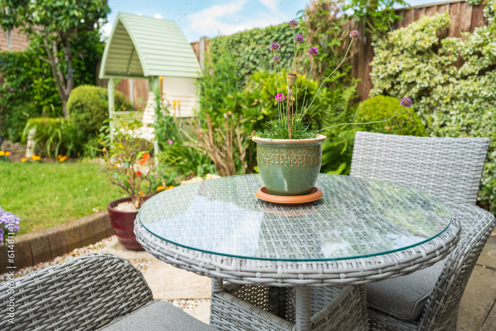 Shallow focus of a pair of chairs and round rattan all-weather table ...