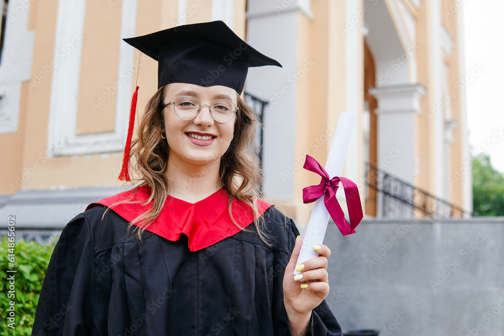 Portrait of a happy smiling graduated student girl in black mortarboard ...