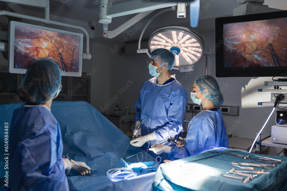 The surgeon's holing the instrument in abdomen of patient. The surgeon ...