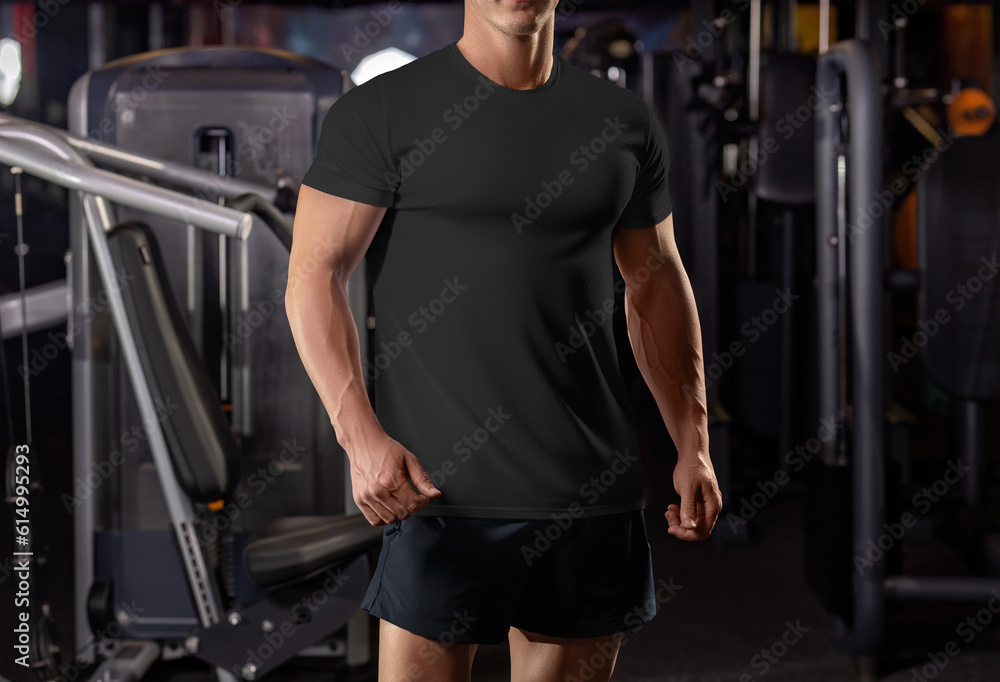 Black t-shirt template on a posing athlete on the background of the gym ...