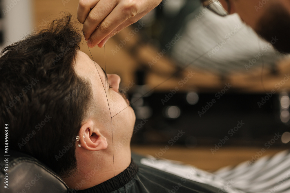 Process of threading procedure in barber shop. Professional barber ...