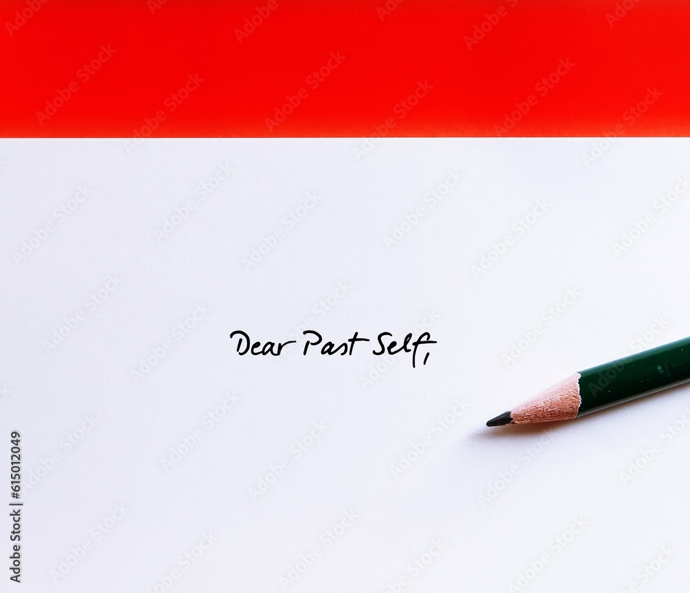 Note paper and pencil on orange background with handwritten text DEAR ...