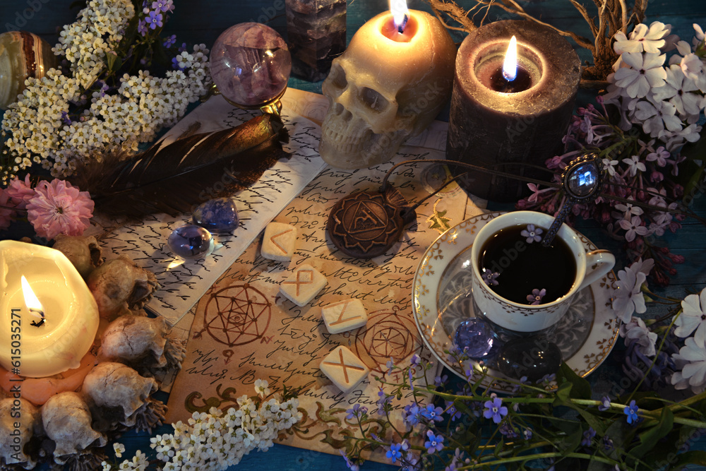 Skull candles, manuscripts with magic spells and runes on witch altar ...