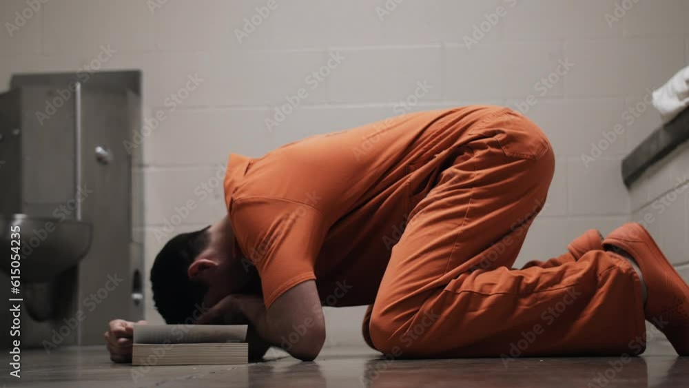 A sad prison inmate, man in prison wearing orange prison jumpsuit ...