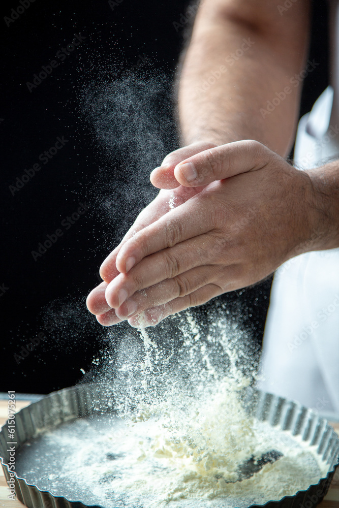 Half body shot of male chef wearing his uniform preparing pastry in the ...