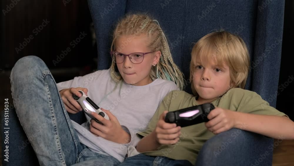 boy and girl playing video game console using joystick or controller ...