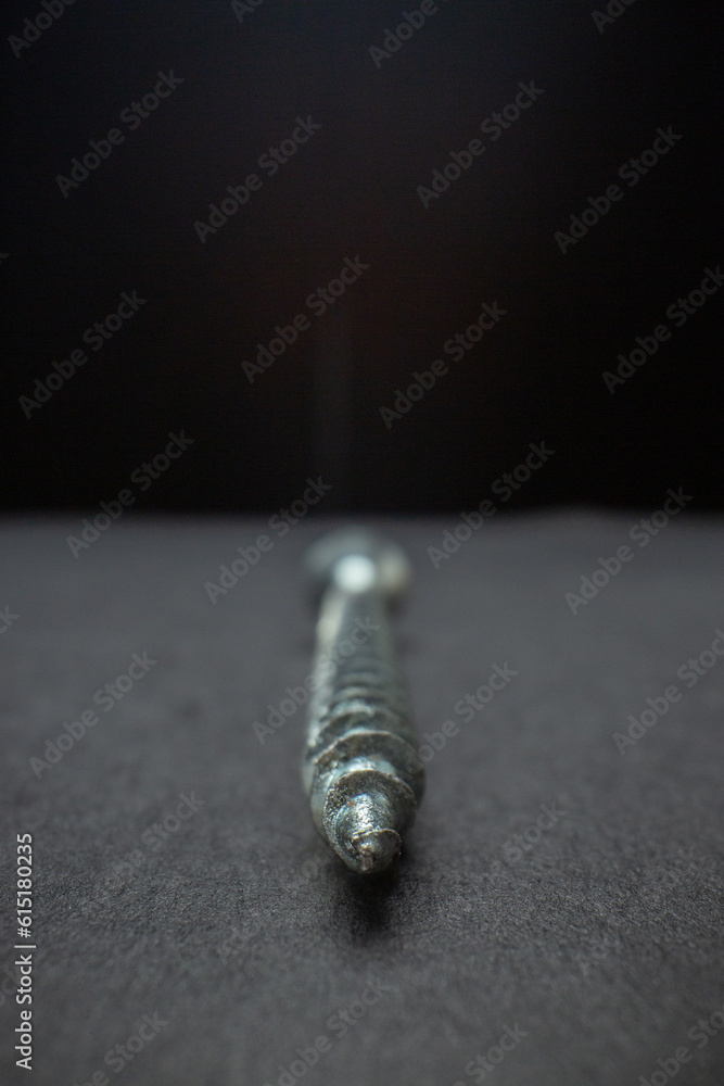 Vertical view of iron tack on isolated black background with free space ...