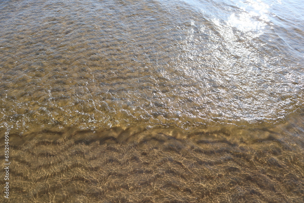 Beautiful background with transparent water and ripples on sandy bottom ...