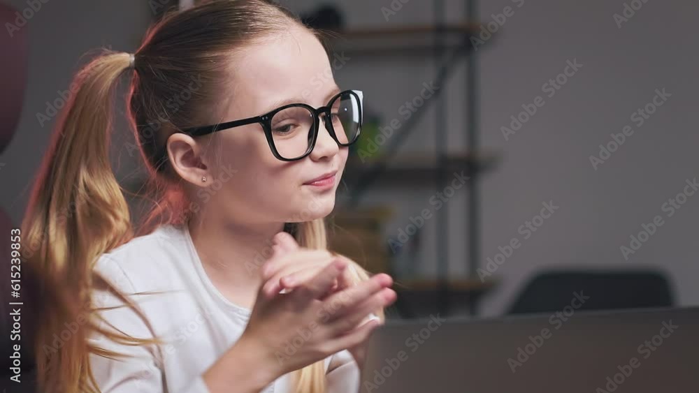 Close up of precious little girl clapping hands while holding video ...