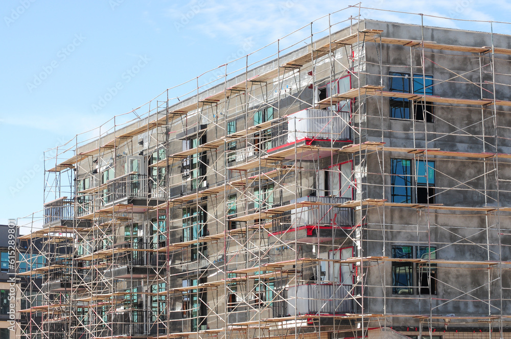 A low-angle exterior view of an apartment building under construction ...