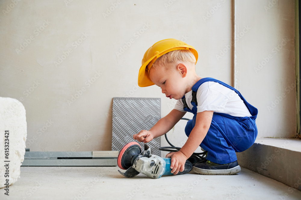Side view of adorable little boy construction worker holding electric ...