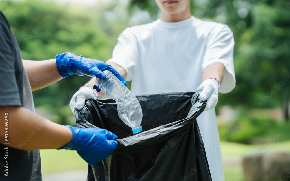 Volunteers of business with garbage bag cleaning park area together for ...