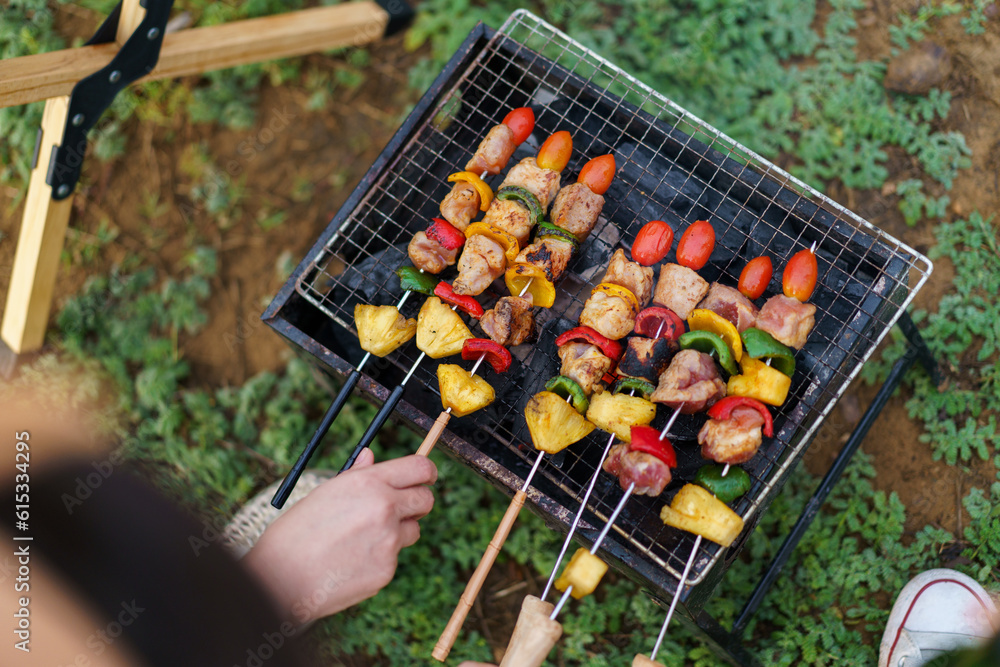 Group of Asian people enjoy grille a meat barbecue - BBQ together during their camping at the ...