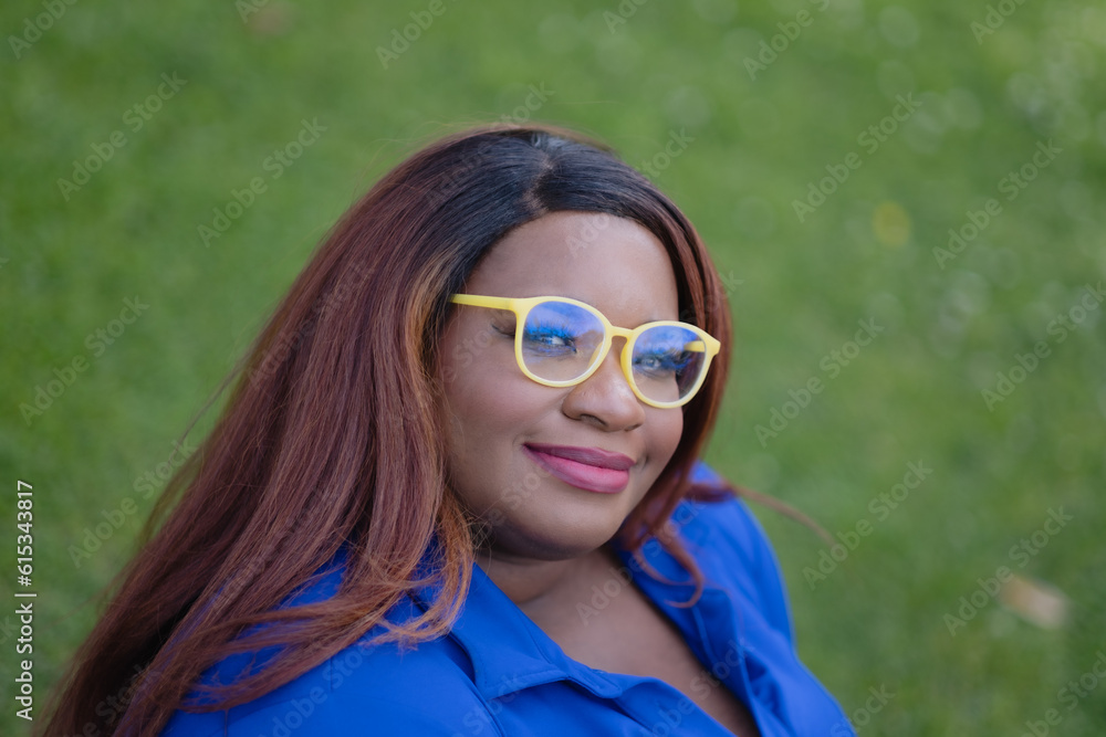 Sitting in a grassy field at a campus, a college-age woman poses for a ...