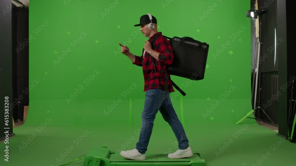 Side view of pizza delivery man in headphones with a thermal backpack ...