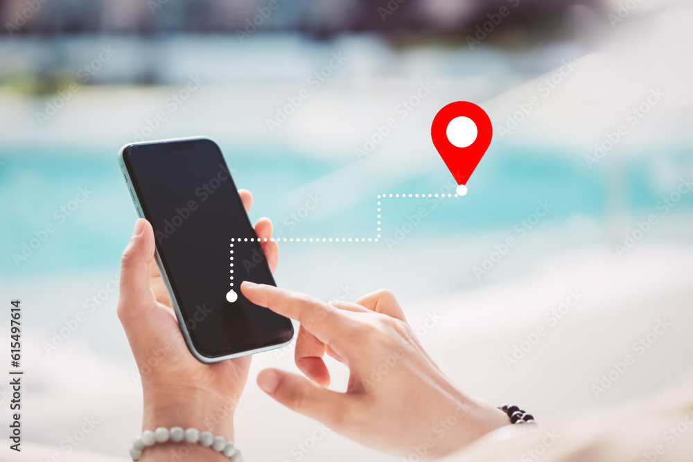Woman hand using smart phone with navigator location point at tropical ...