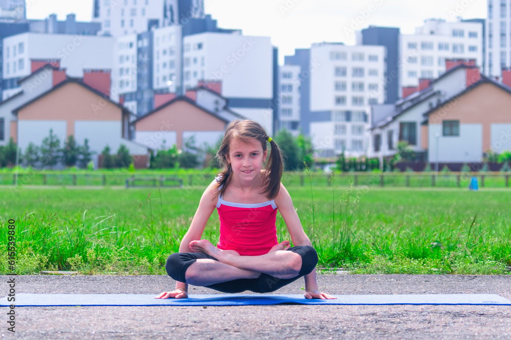 Portrait of young sporty attractive girl doing yoga exercise on blue ...
