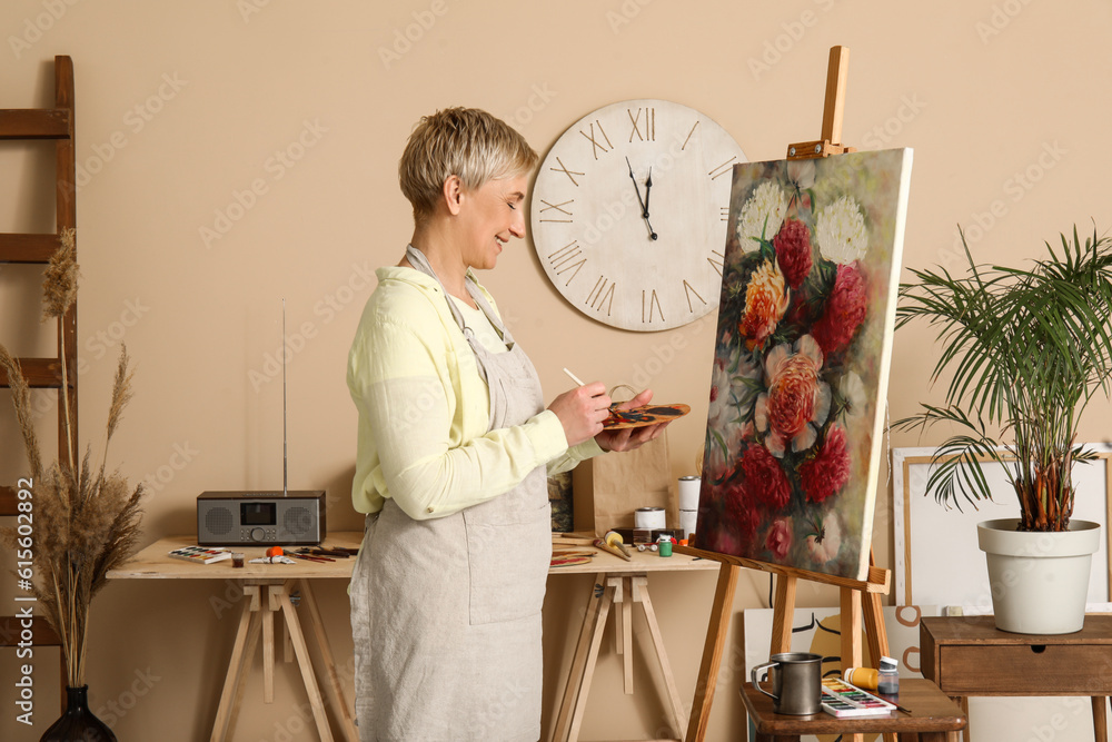 Mature female artist painting picture in workshop Stock Photo | Adobe Stock
