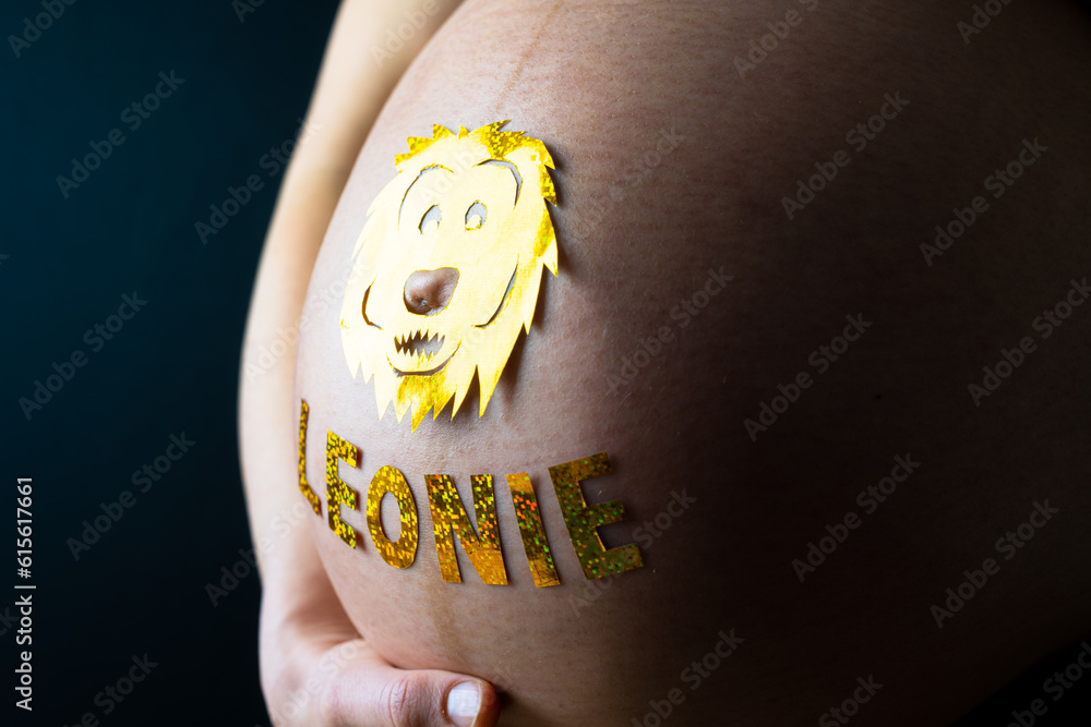 Baby bump shot with glittering lion sticker and child name from the ...
