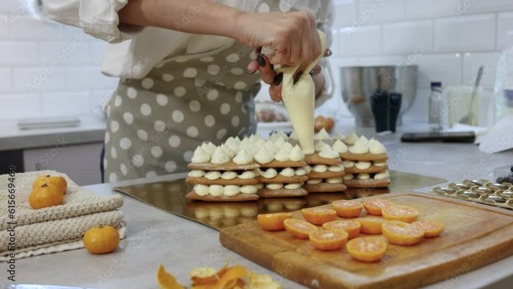 cook a cake in the kitchen. Young female pastry chef cooking a layered ...