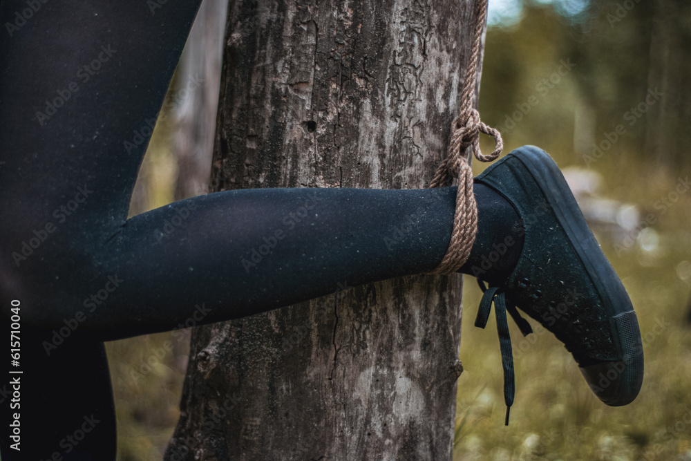 tied up legs of a woman in green body and black tights with a natural ...