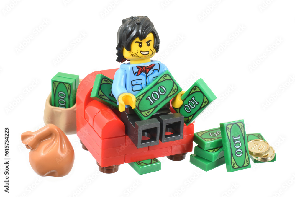 Lego minifigure of happy male is sitting on the chair and counting his ...