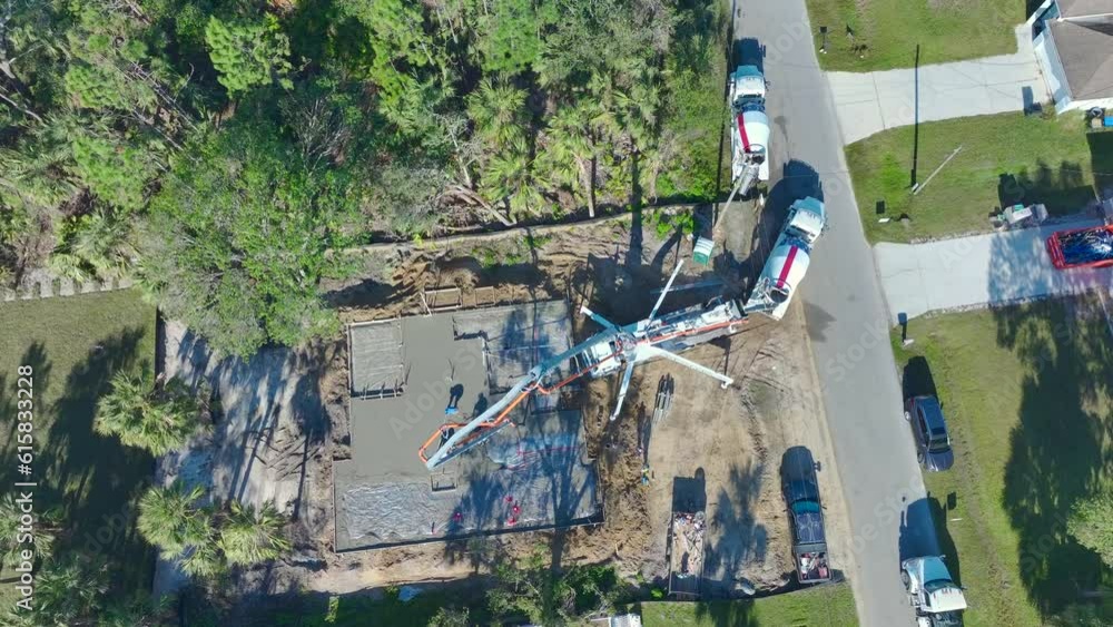 Construction workers at new house building site pouring concrete of ...