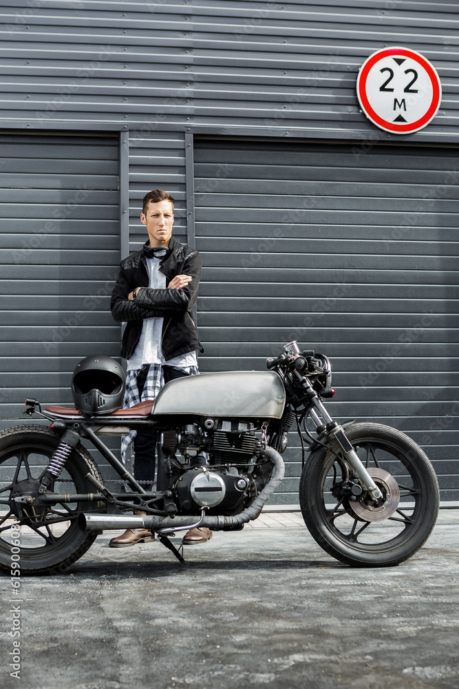 Handsome rider man with crossed arms in black biker jacket near classic ...
