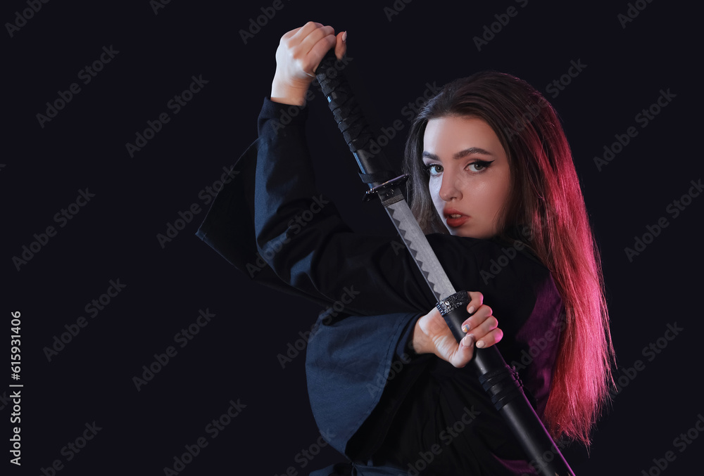 Beautiful young woman with katana on black background Stock Photo ...