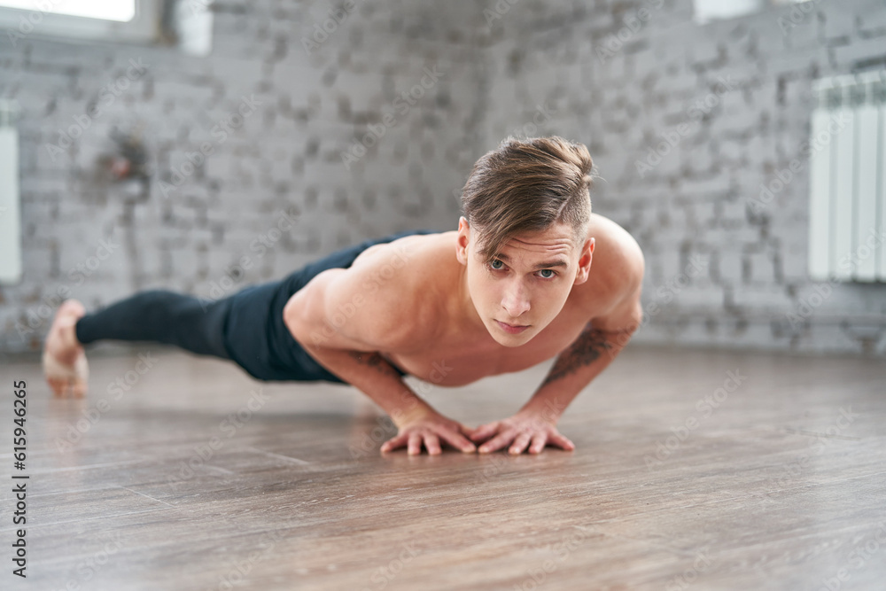 Athletic young man doing push ups on the floor. Young man workout in ...