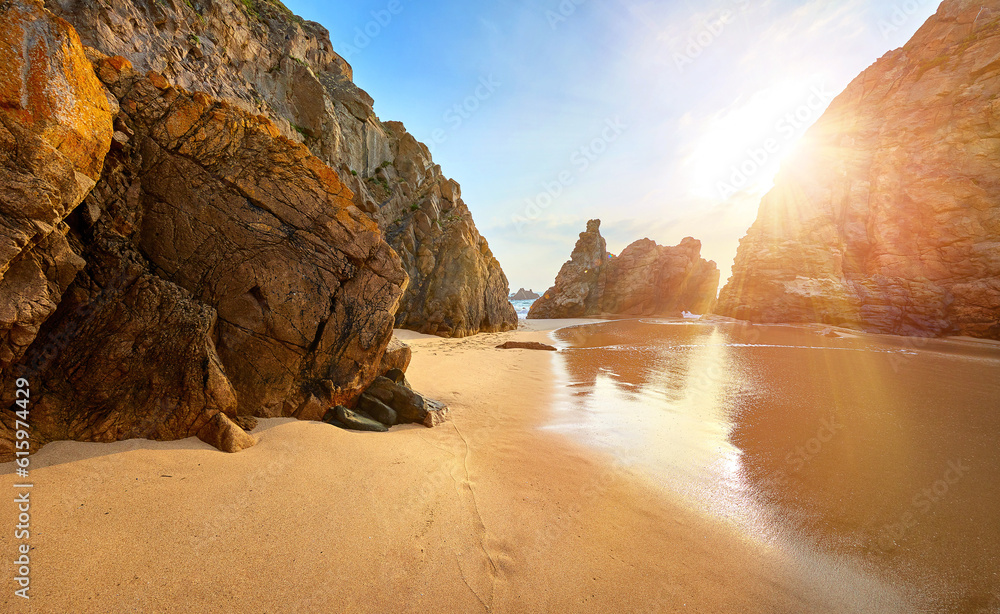 Sand beach among rocks on evening sunset. Ursa Beach near Cape Roca ...