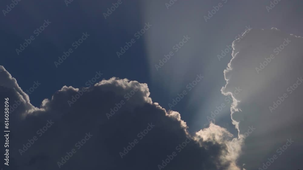 Sun rays behind the cloud during the day. Light rays behind the clouds ...