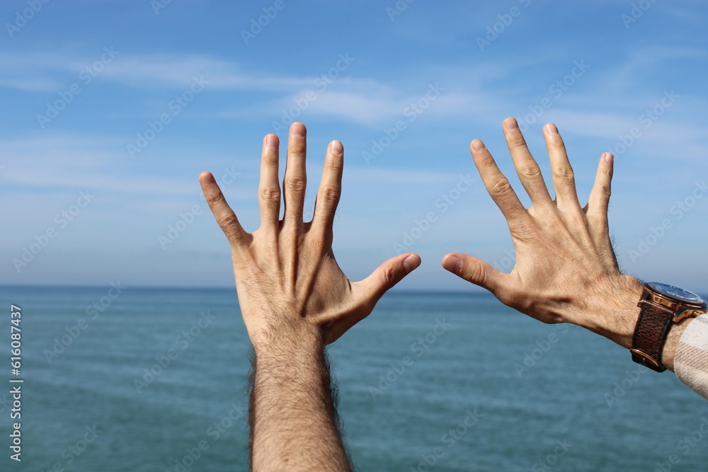 Hand doing,showing number nine gesture symbol on blue summer sky nature ...
