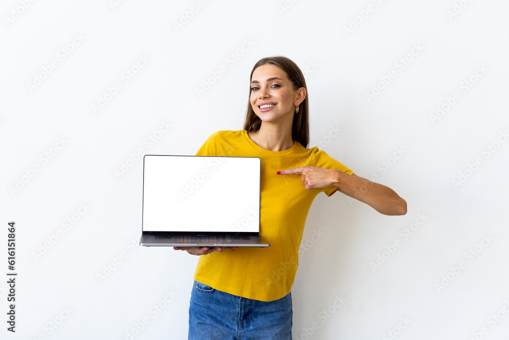 Portrait of a cheerful woman showing blank laptop computer screen ...