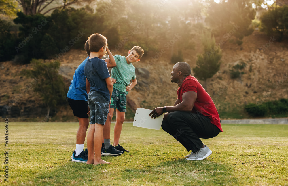 Coach having a team talk with children in a school ground Stock Photo ...