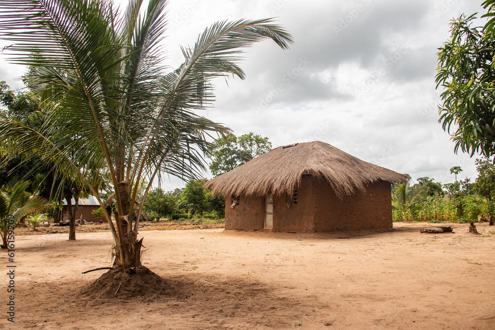 Typical rural mud-house in remote village in Africa with thatched roof ...