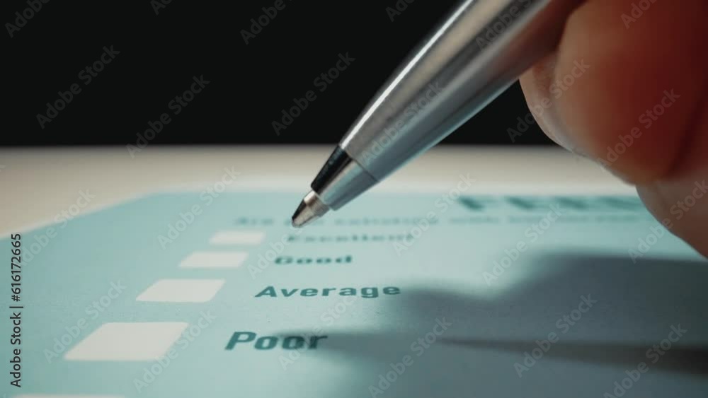 Closeup macro shot movement hand filling feedback survey form with pen ...
