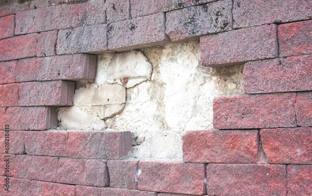 Destroyed brick wall. Destroyed part of a brick wall and plaster ...