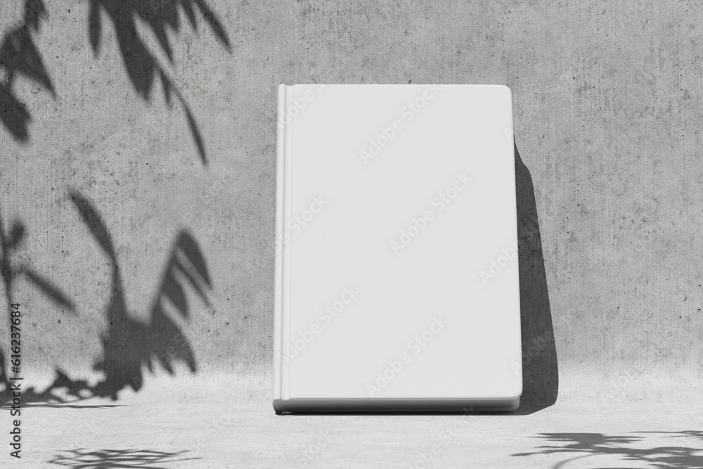 Mockup of a closed blank hardback book on a clear day against a gray ...