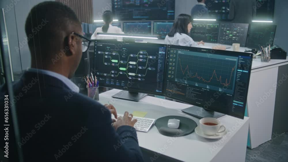 African American big data scientist works at computer with displayed ...