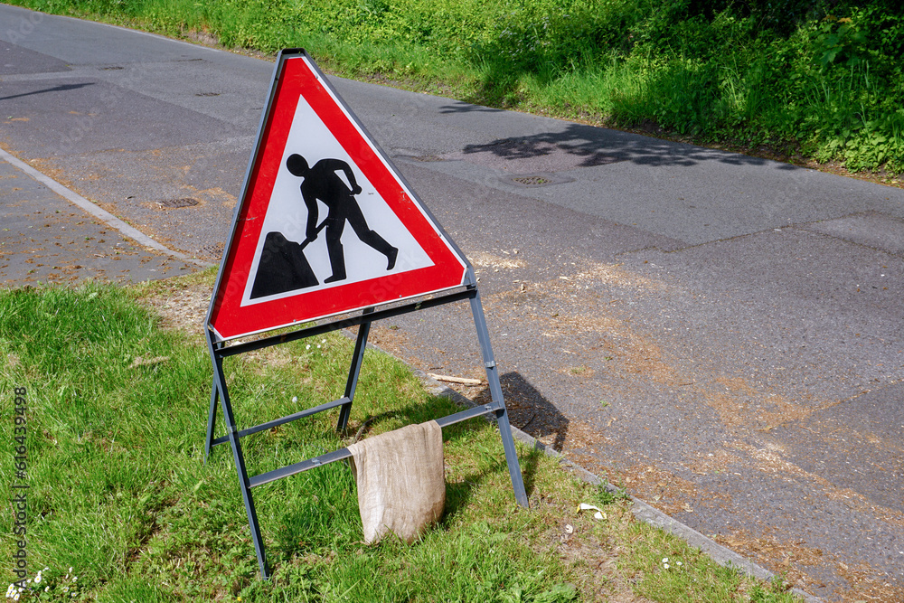 Road works warning sign on quiet country lane. Road maintenance ahead ...