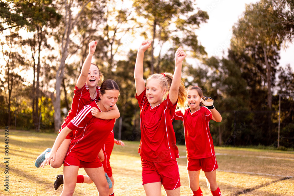 Foto de Happy football team of tween girls celebrating together do ...